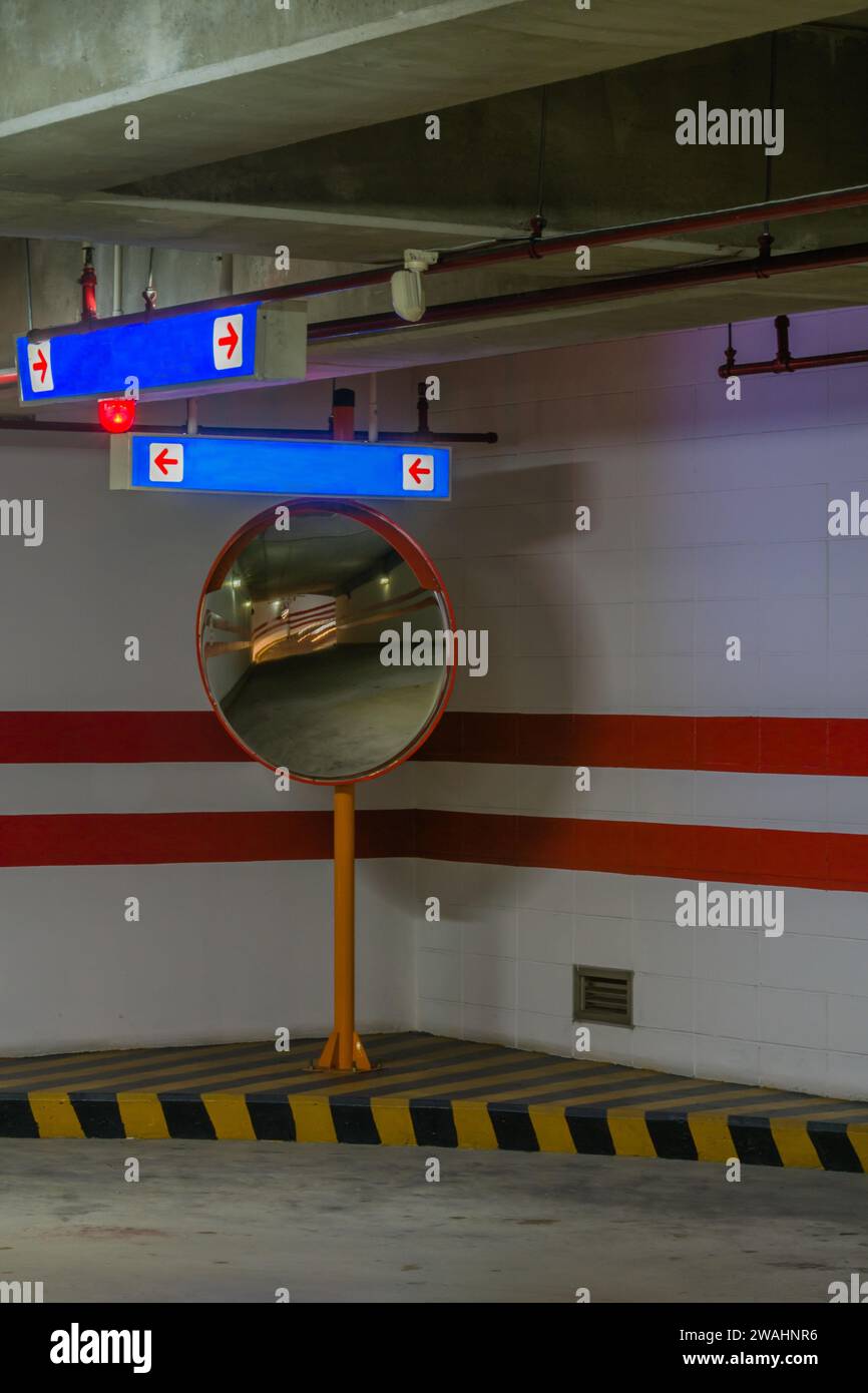 Large round parking garage mirror with reflection of light trails from ...