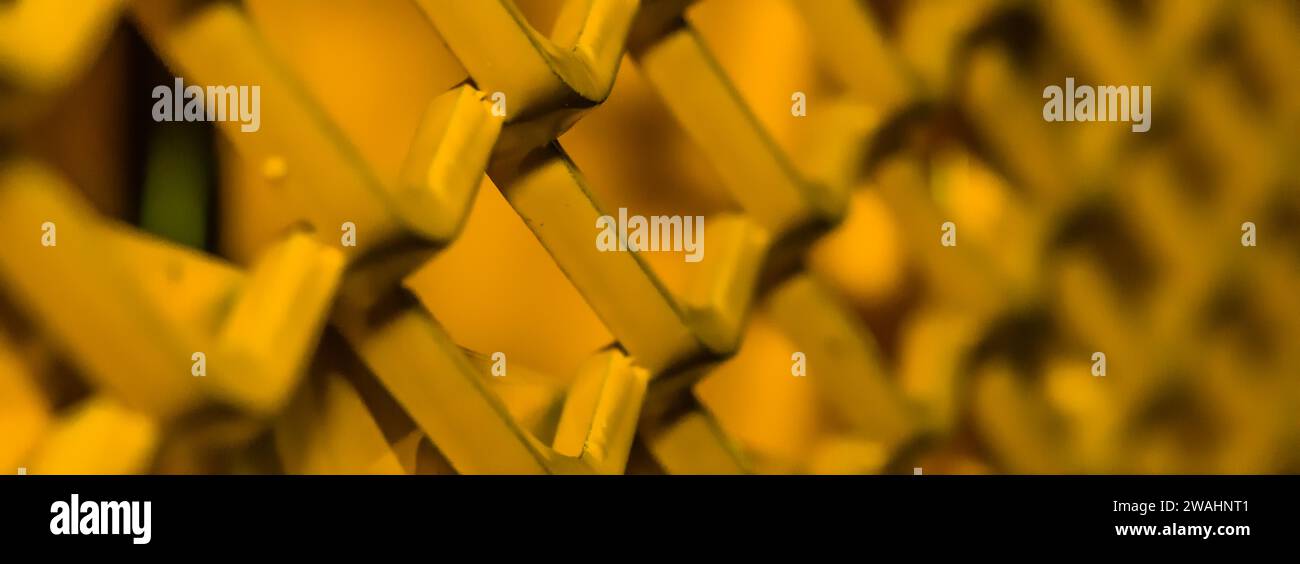 Macro of yellow metal grate with blur in both foreground and background ...