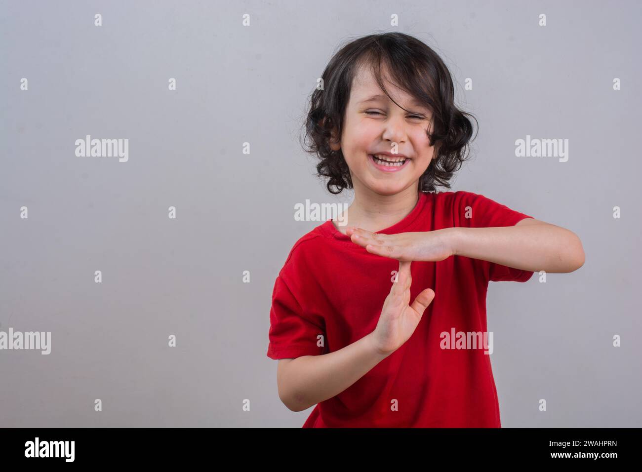 Smiling little boy making a pause or break time hand gesture Stock ...