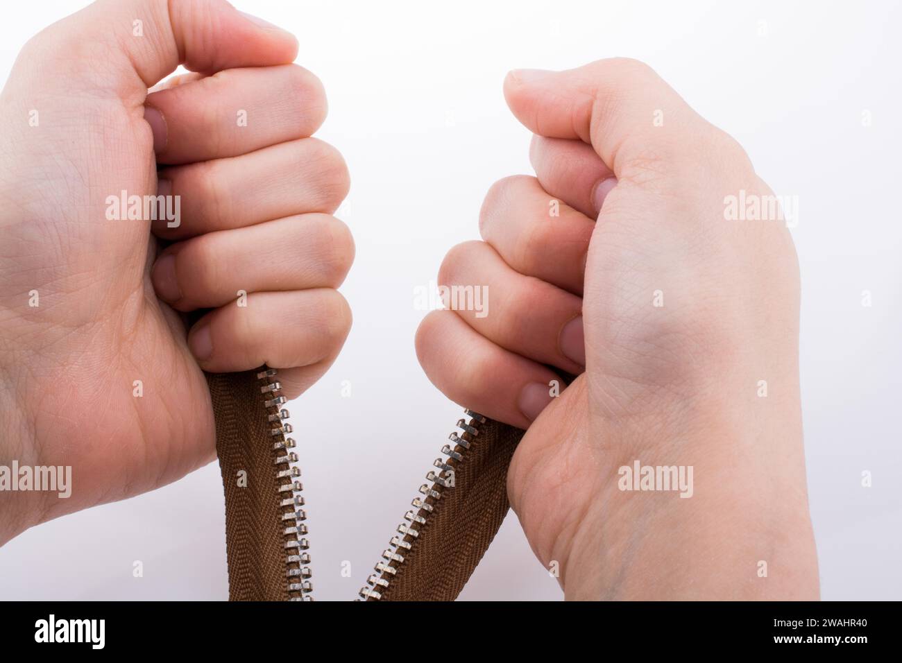 Hand holding color zipper on a white background Stock Photo - Alamy