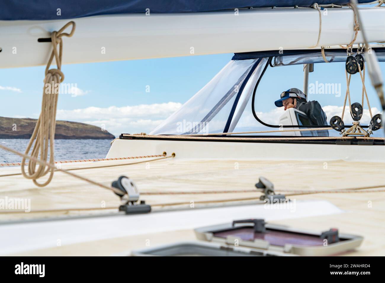 Captain steering a sailboat on a serene Maui whale watching tour Stock ...