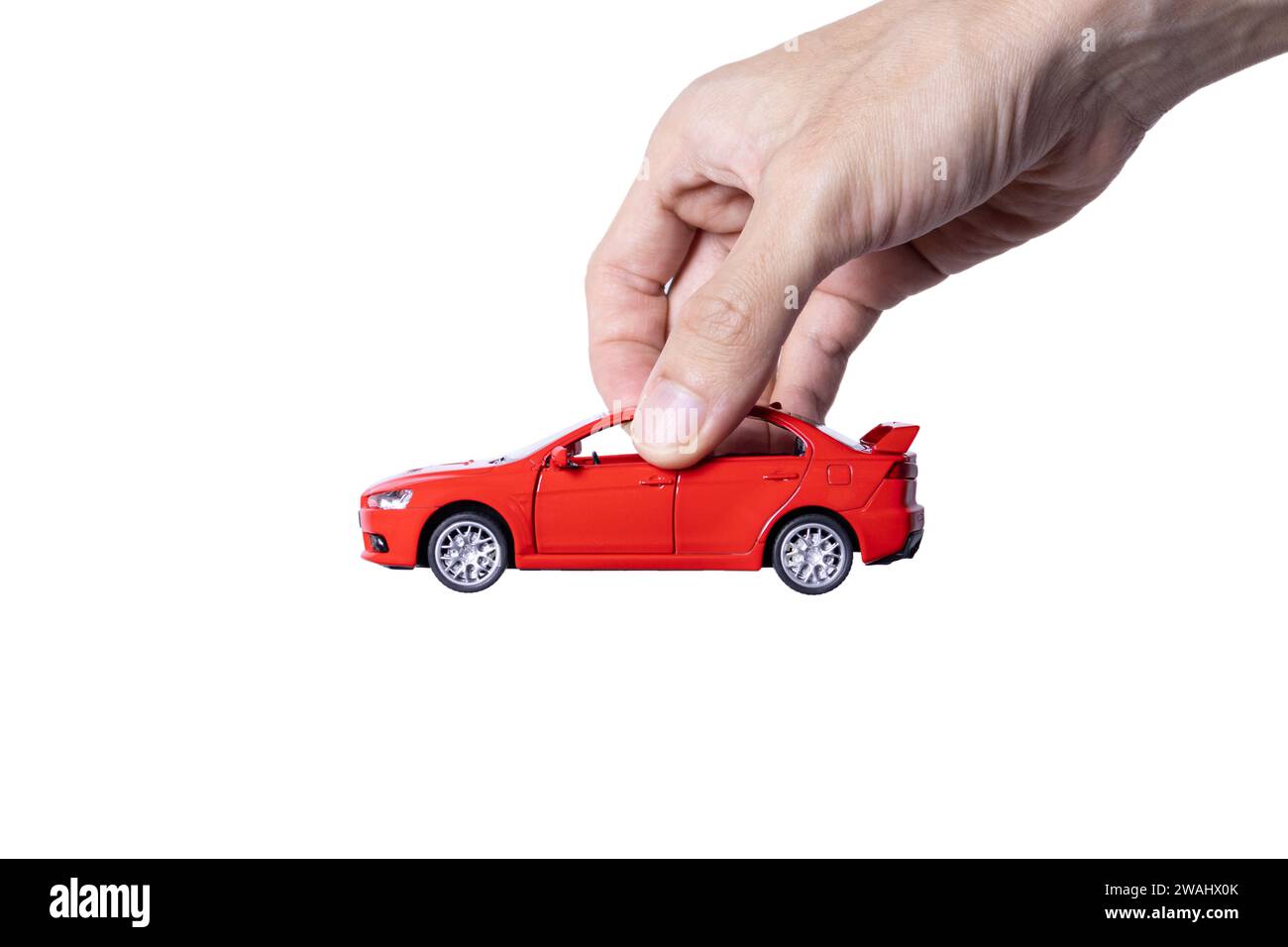 Hand holding a toy car isolated on white background. After some edits ...
