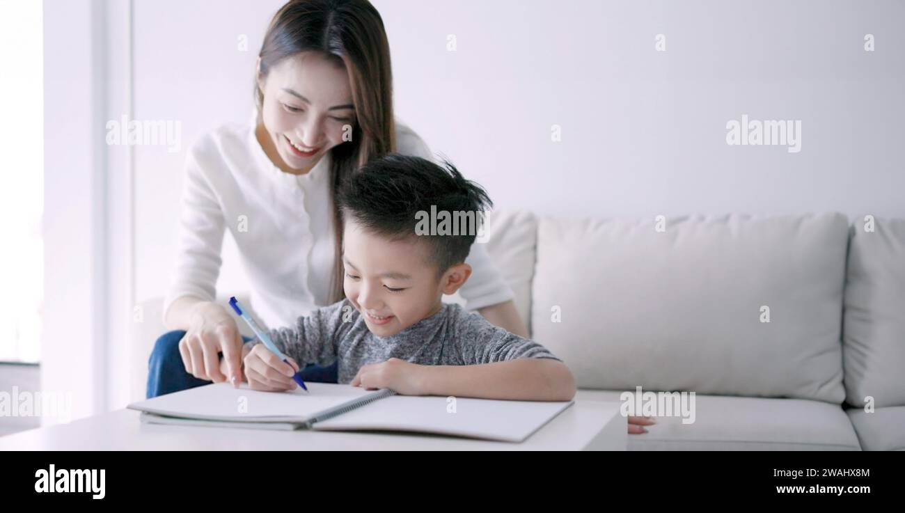 Young mother checking homework helping child with study at home Stock ...
