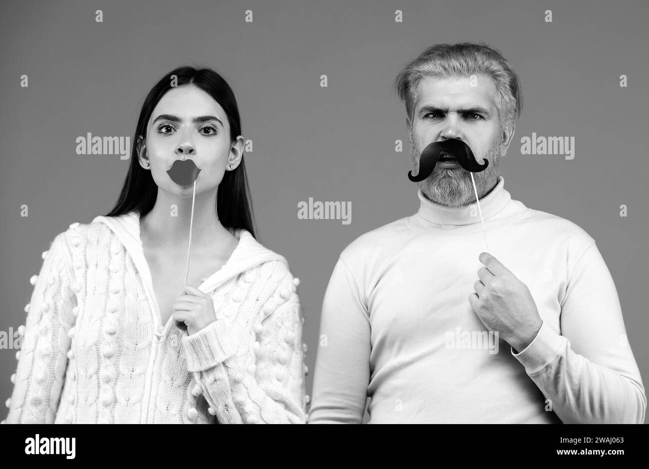 party props. Happy couple having fun with with fake mustache and lips ...