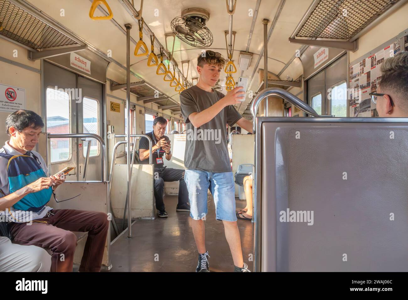 Passengers with cell phones on the railway train from Ban Na Khwang to ...