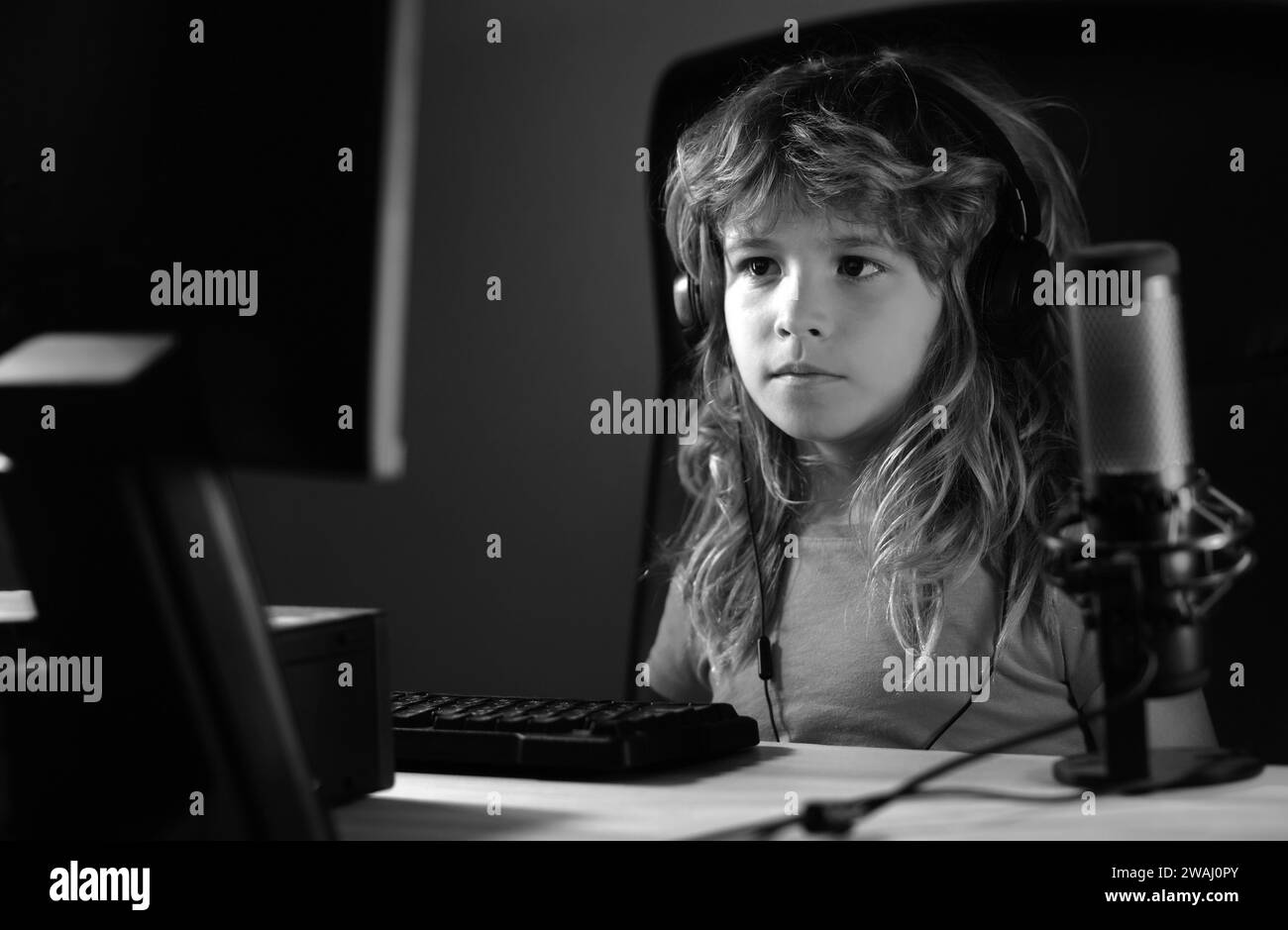 Child plays a video game on the pc computer screen. School, study, online learning concept ...