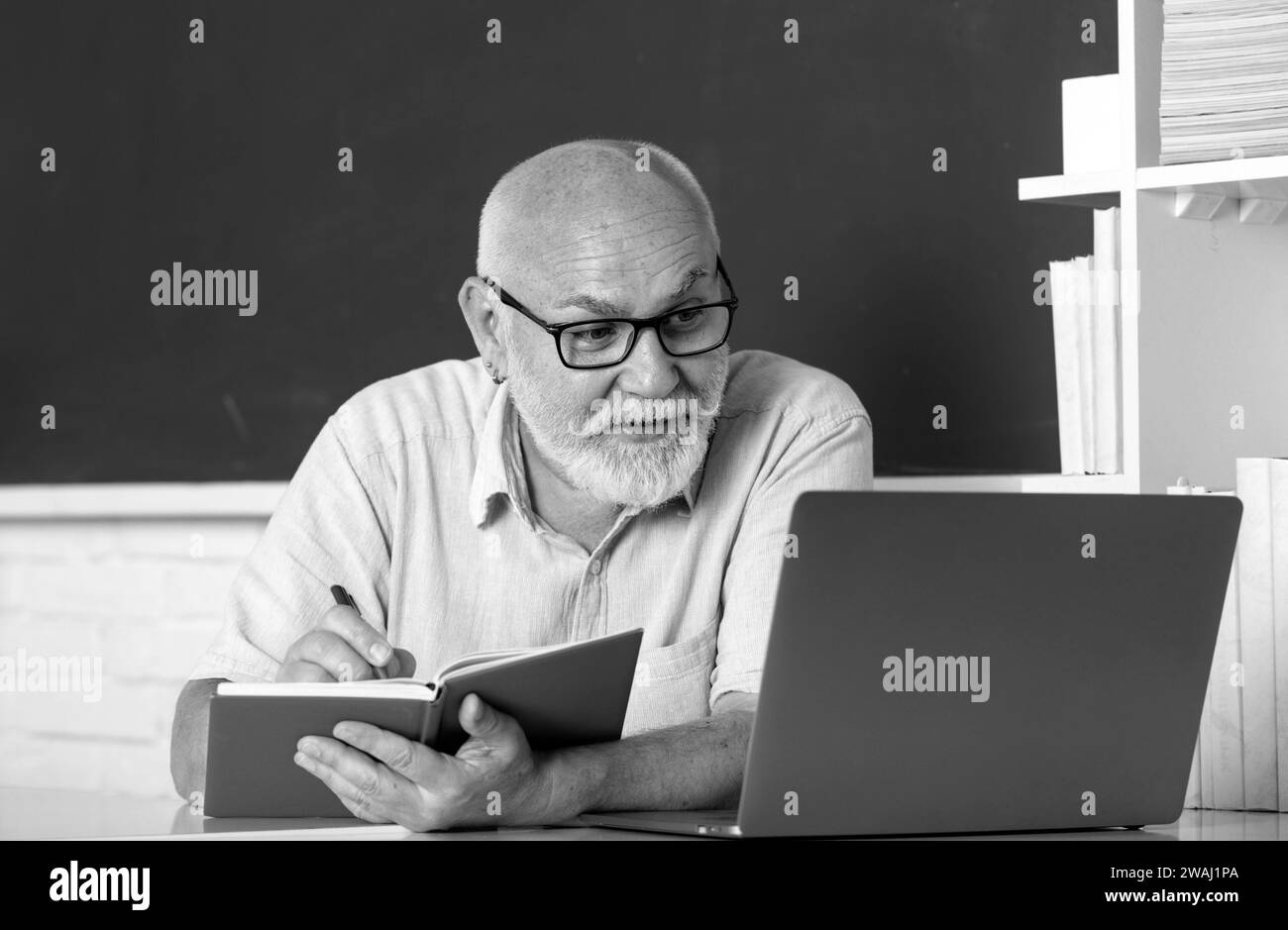 Portrait of senior teacher teaching line of high school students with ...