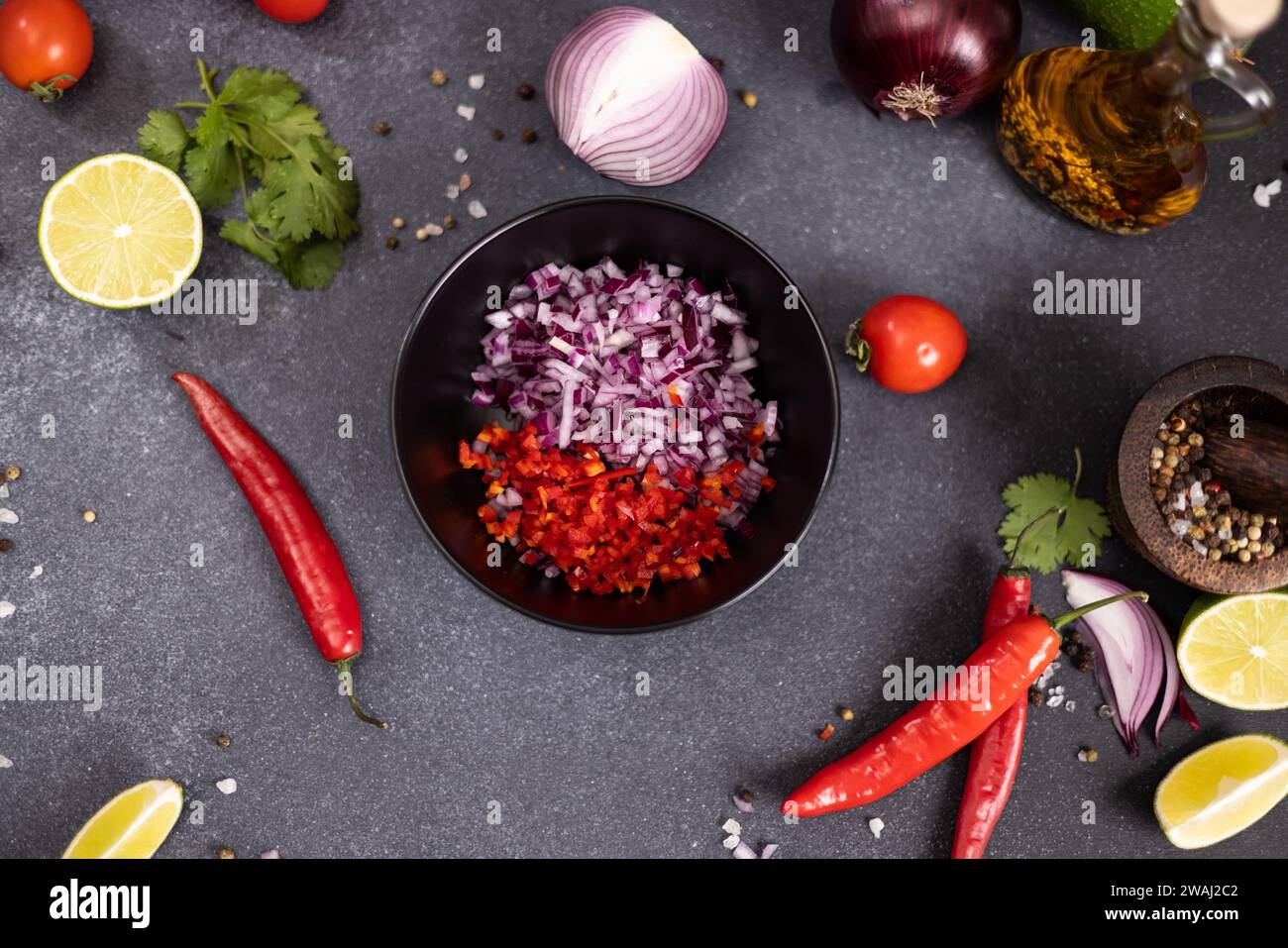 Cooking mango salsa - sliced chopped ingredients in a black ceramic ...