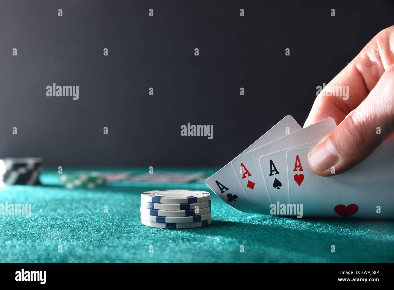 Hand showing four aces playing cards on a table with green mat with ...