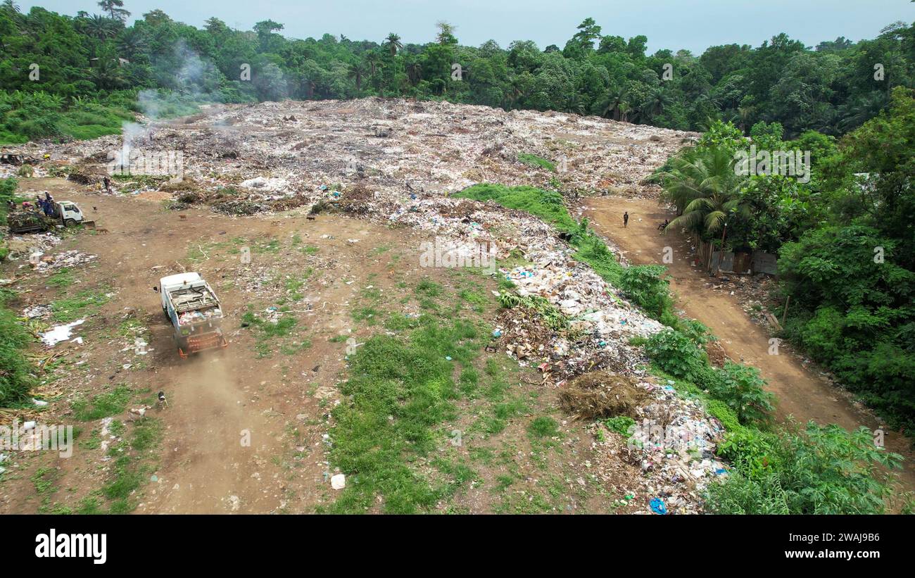A desolate landscape with an array of industrial trash trucks moving ...
