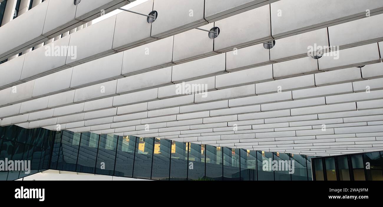 A modern office building with a glass facade illuminated by several ...