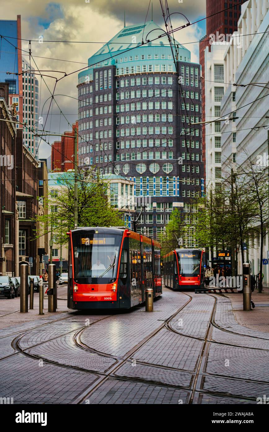 Red trams navigating through the urban tramlines in the bustling ...