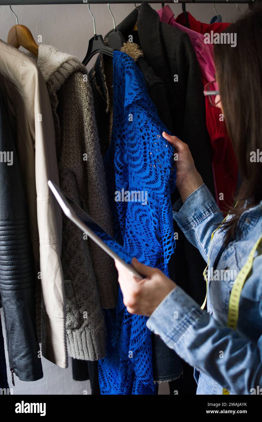 A tailor examining a vibrant blue lace fabric amidst an assortment of ...