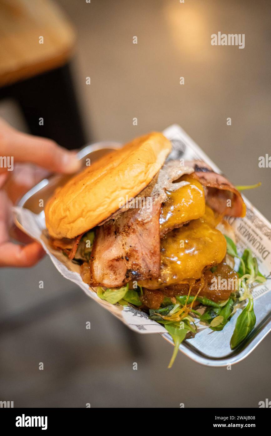 From above cropped unrecognizable person's hand holding a gourmet beef ...