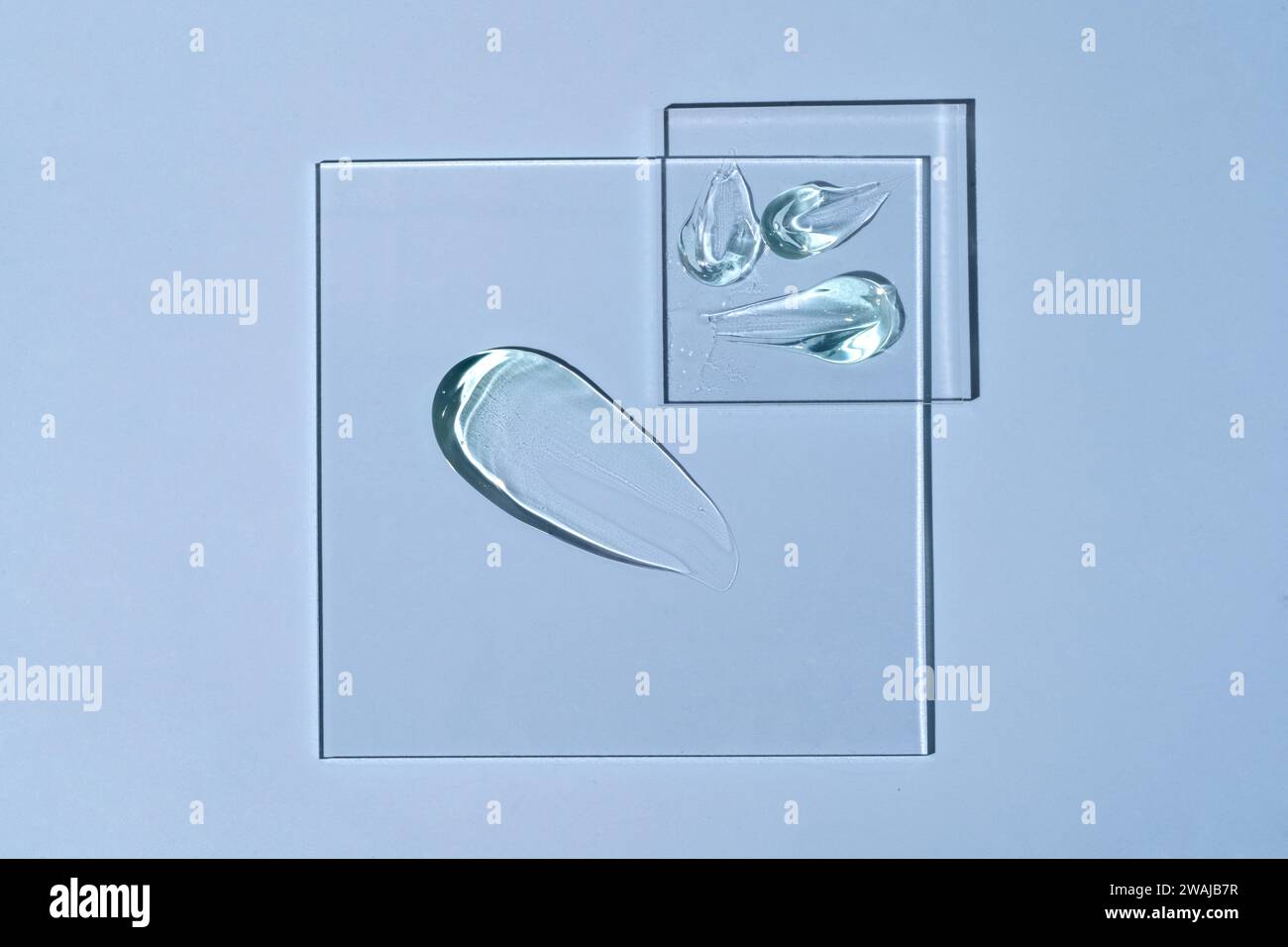 Artistic layout of clear skincare gel samples on glass squares with a ...