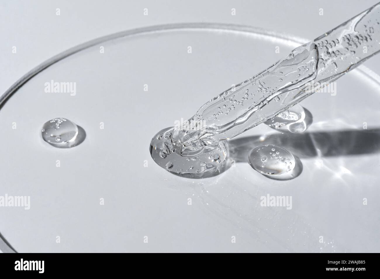 Close-up image capturing a serum dropper dispensing a viscous liquid ...