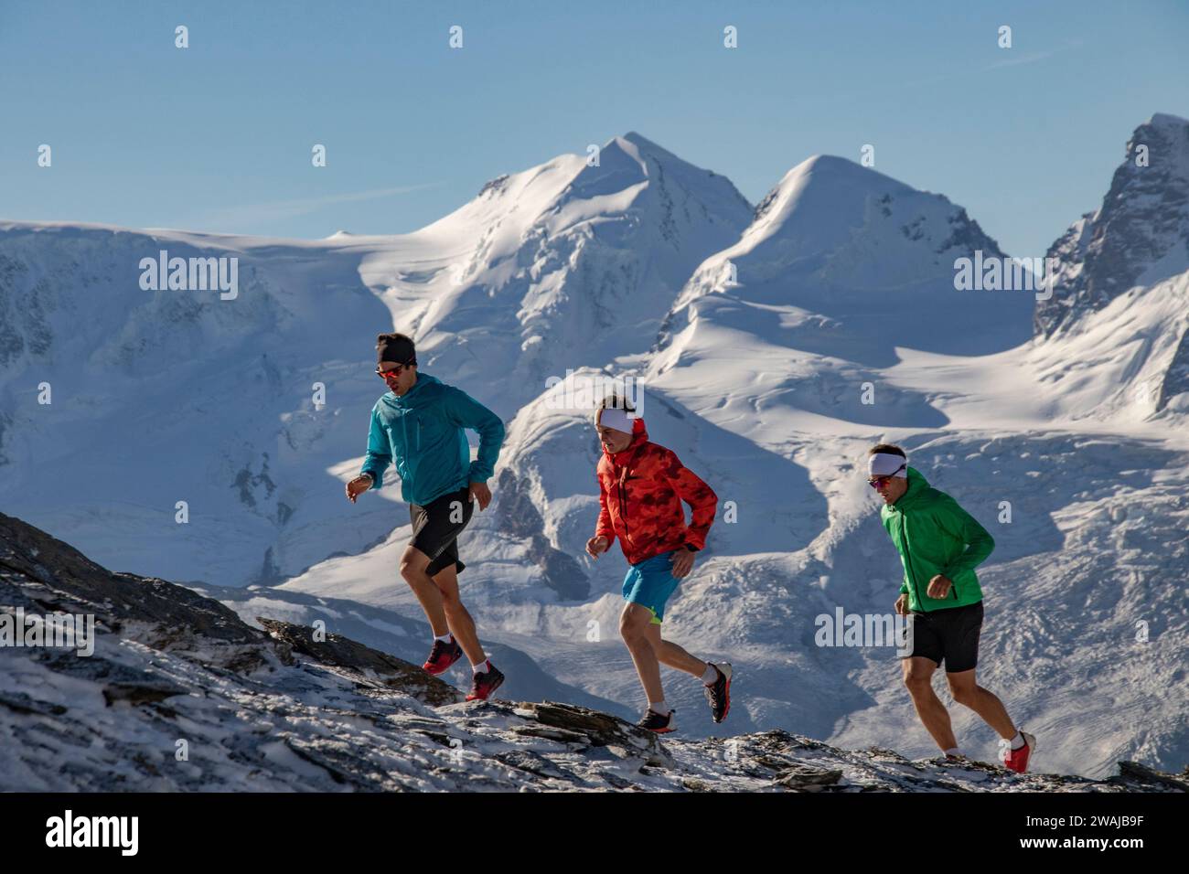 Full body of trio of runners in colorful attire on a mountain run with ...