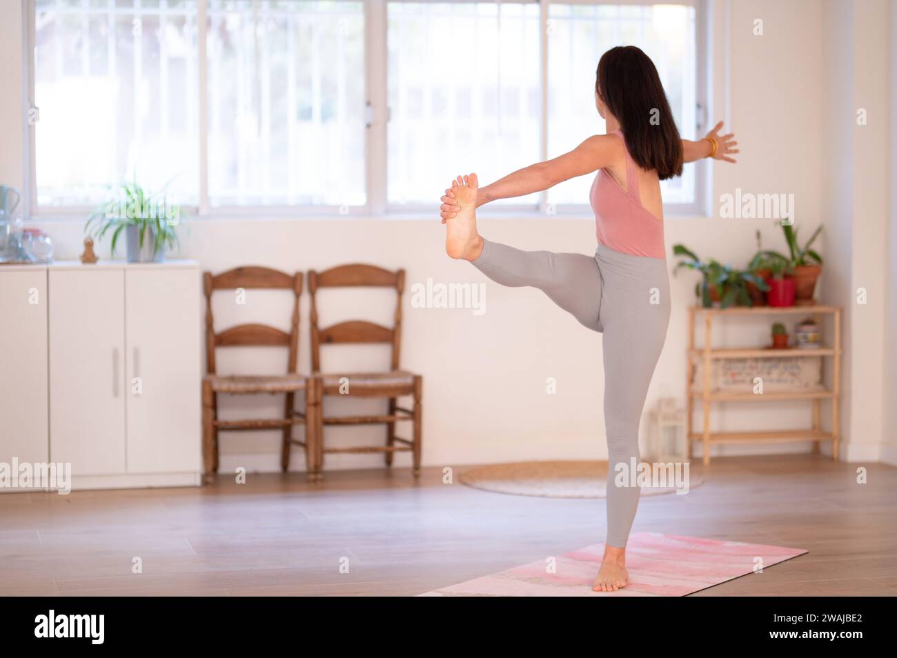 Full body of flexible anonymous woman in activewear balancing on one ...