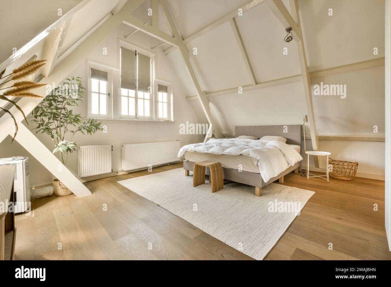 Large and comfortable bed in attic bedroom of luxurious home with ...