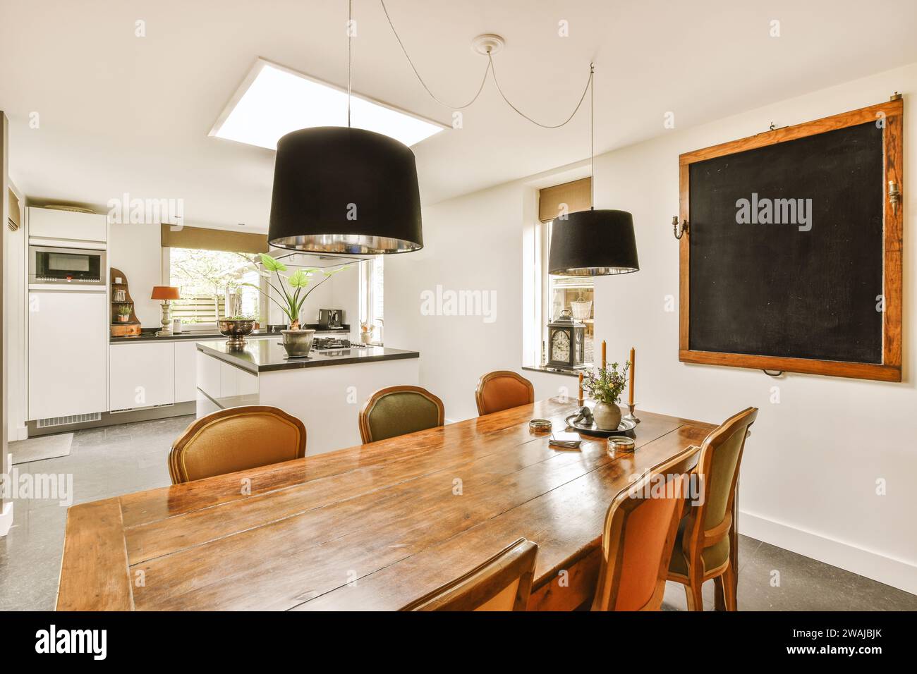 Pendant lights hanging over wooden table and chairs with empty blank ...