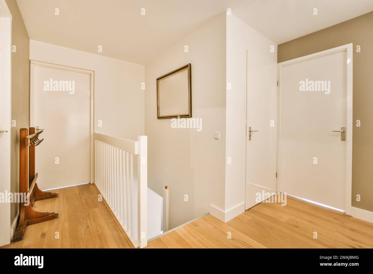 Empty corridor with white closed doors of rooms with hardwood floor at ...