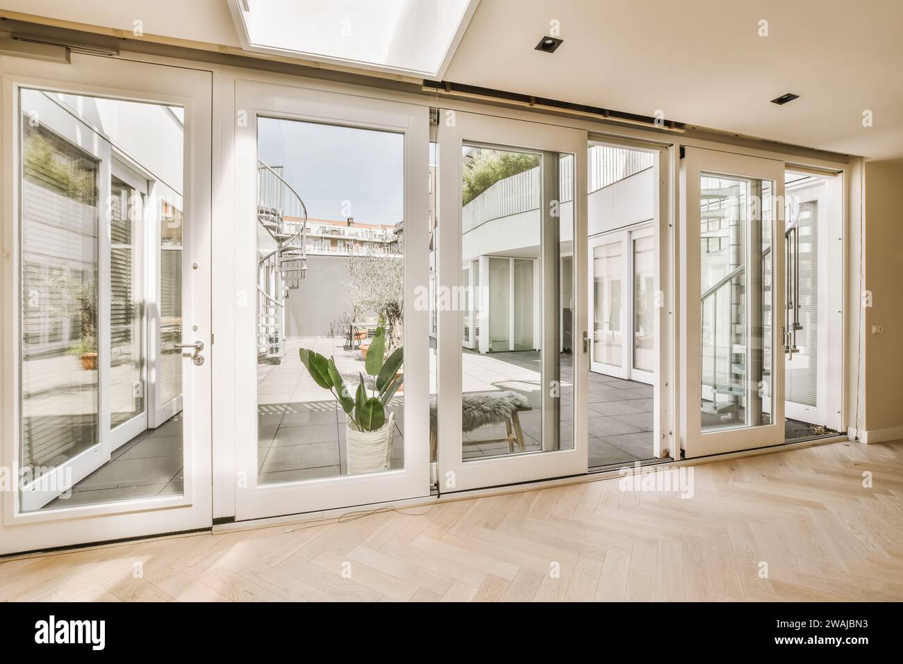 Large glass windows with white sliding doors in living room with ...