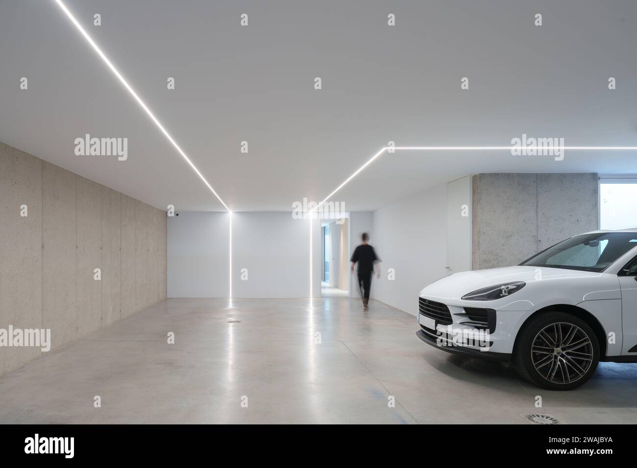 Unrecognizable person walking in contemporary garage with integrated ...