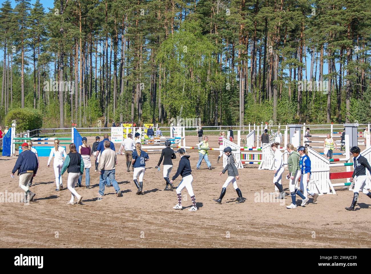 Young riders walk the course as preparation for a show-jumping ...