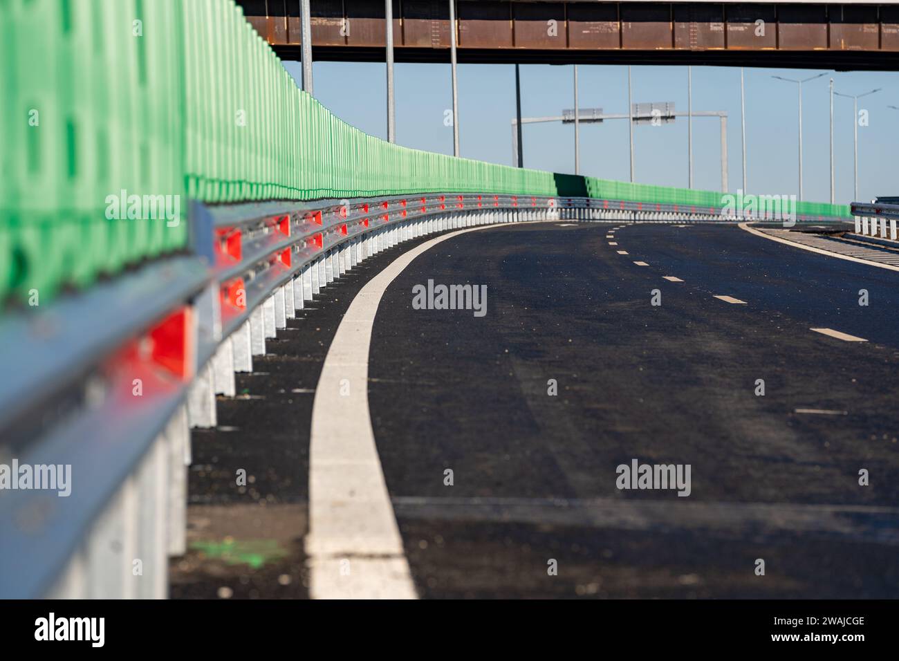 The green metallic fence posts lining the side of an asphalt road Stock ...