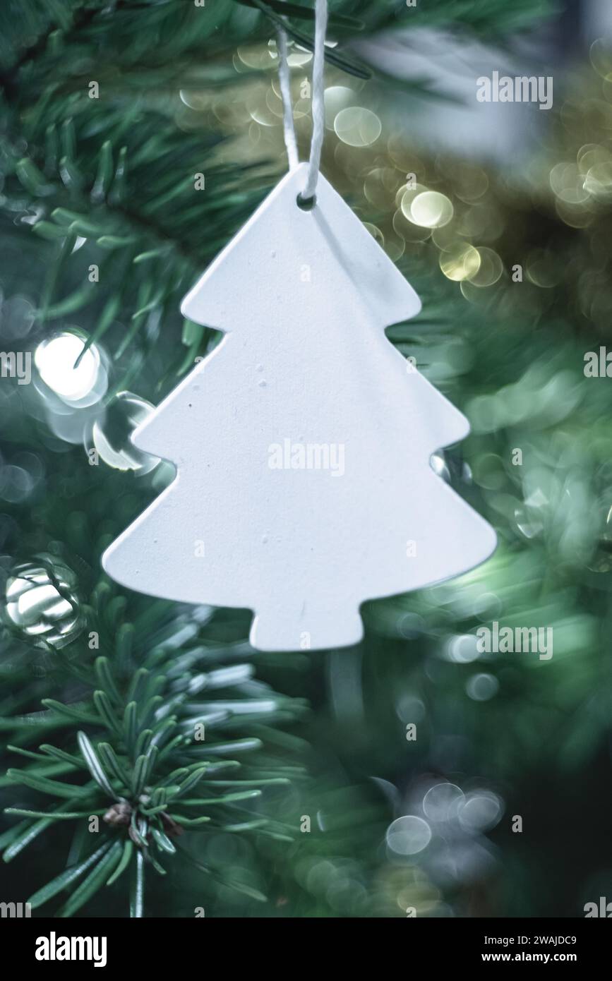 A small white Christmas tree decoration hanging from the branches of a ...