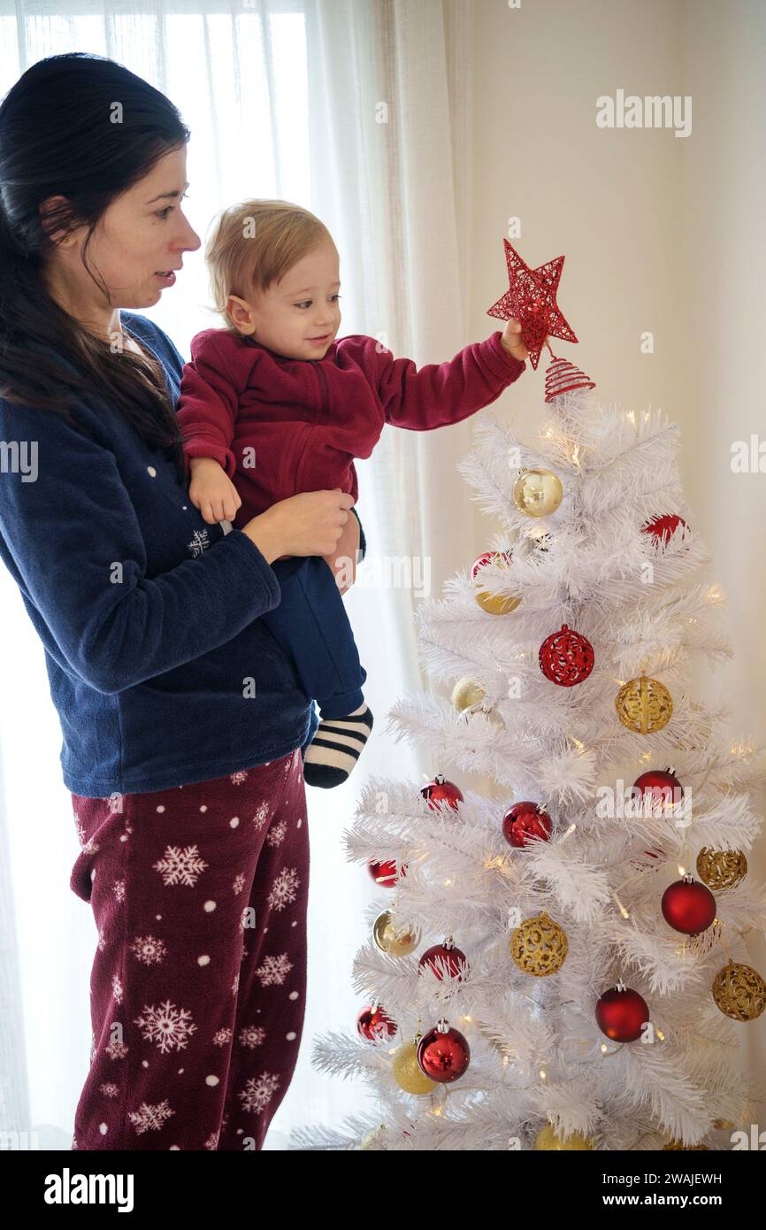 16 month old toddler helping his mother set up festive decorations on ...