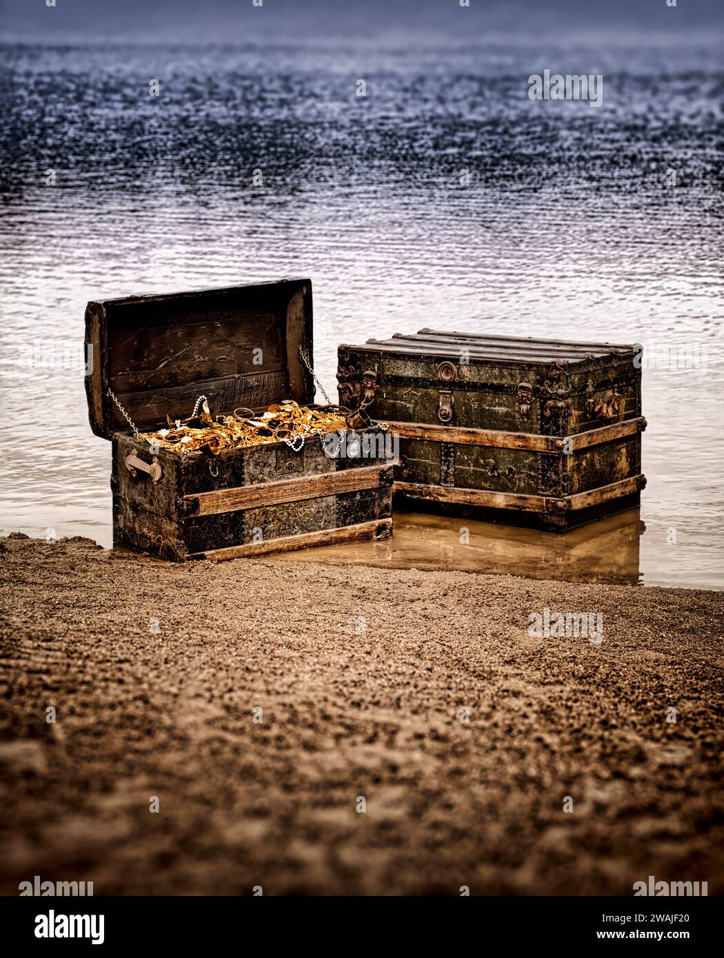 The two ornately decorated treasure chests, resting in the shallow ...