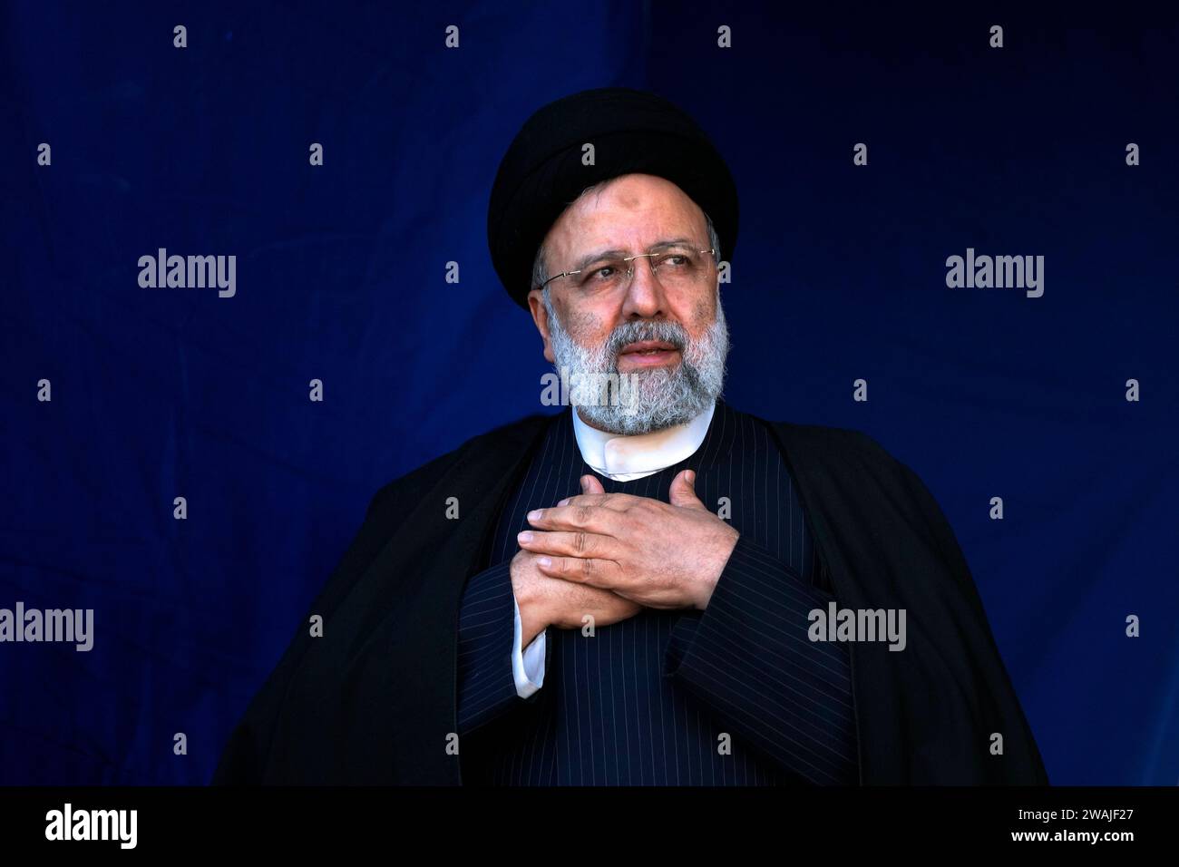 Iranian President Ebrahim Raisi places his hands on his heart as a ...