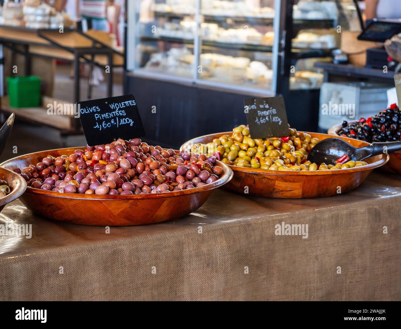 Bowls of fresh red and green large olives for sale at an outdoor market ...