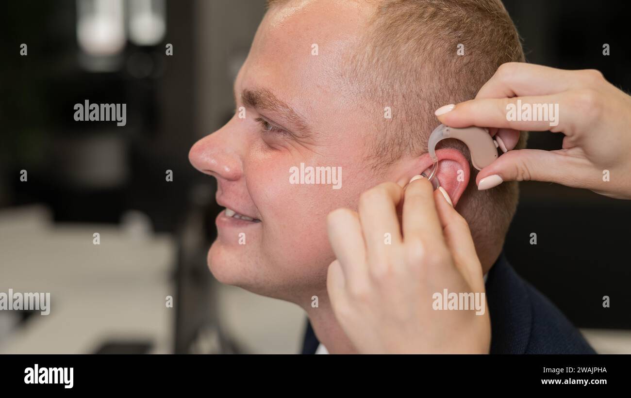 Audiologist putting hearing aid hi-res stock photography and images - Alamy