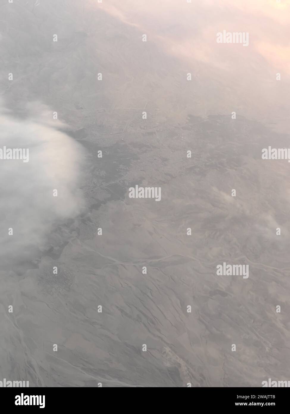 View from airplane at clouds, under clouds of mountains Stock Photo - Alamy