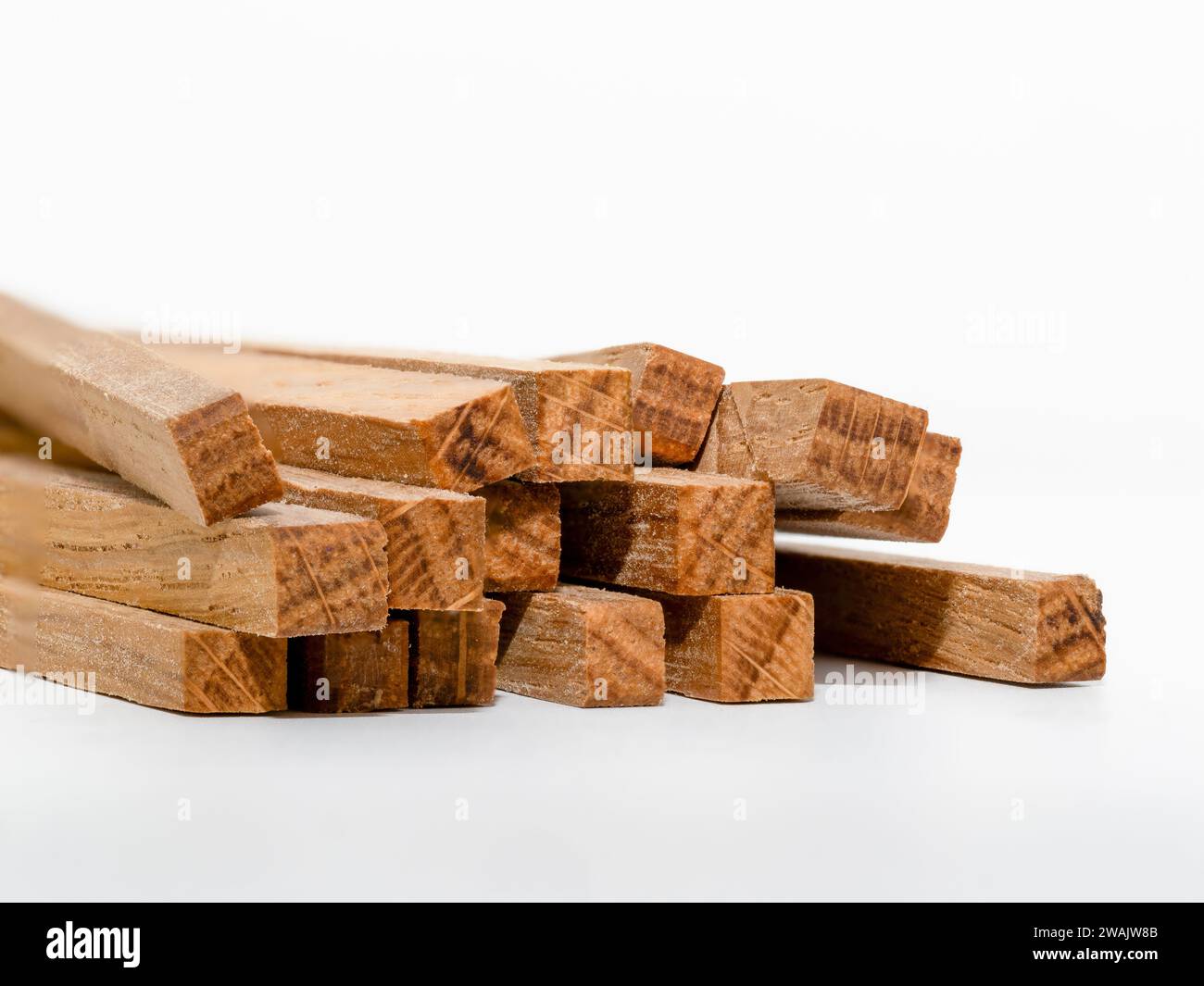 stack of planed and finished hardwood square posts isolated on a white ...