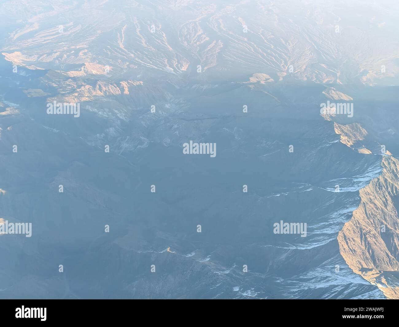 View from airplane at clouds, under clouds of mountains Stock Photo - Alamy