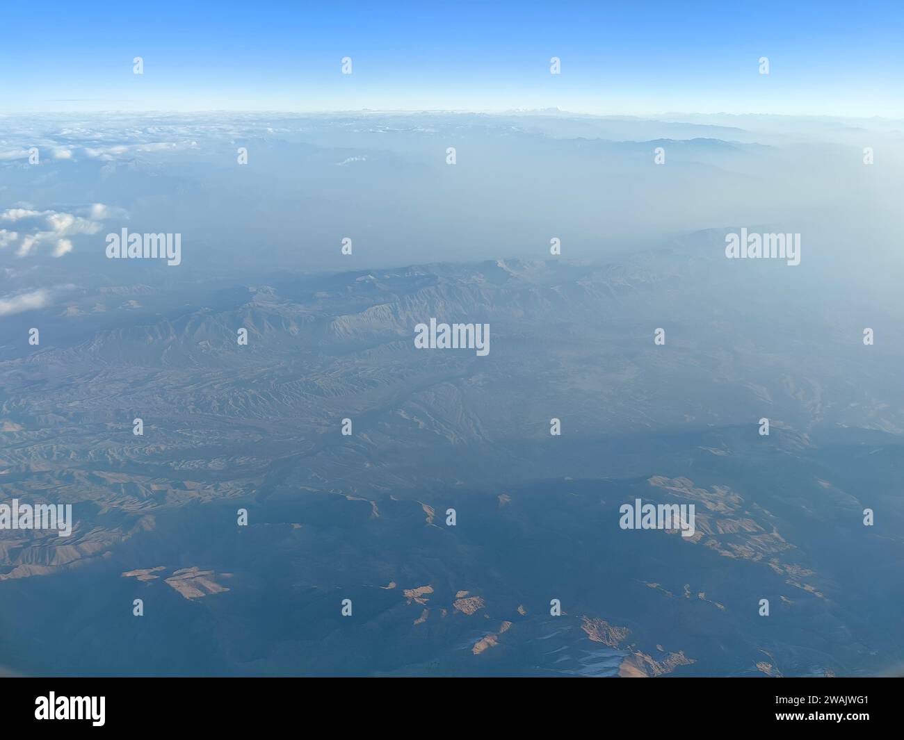 View from airplane at clouds, under clouds of mountains Stock Photo - Alamy