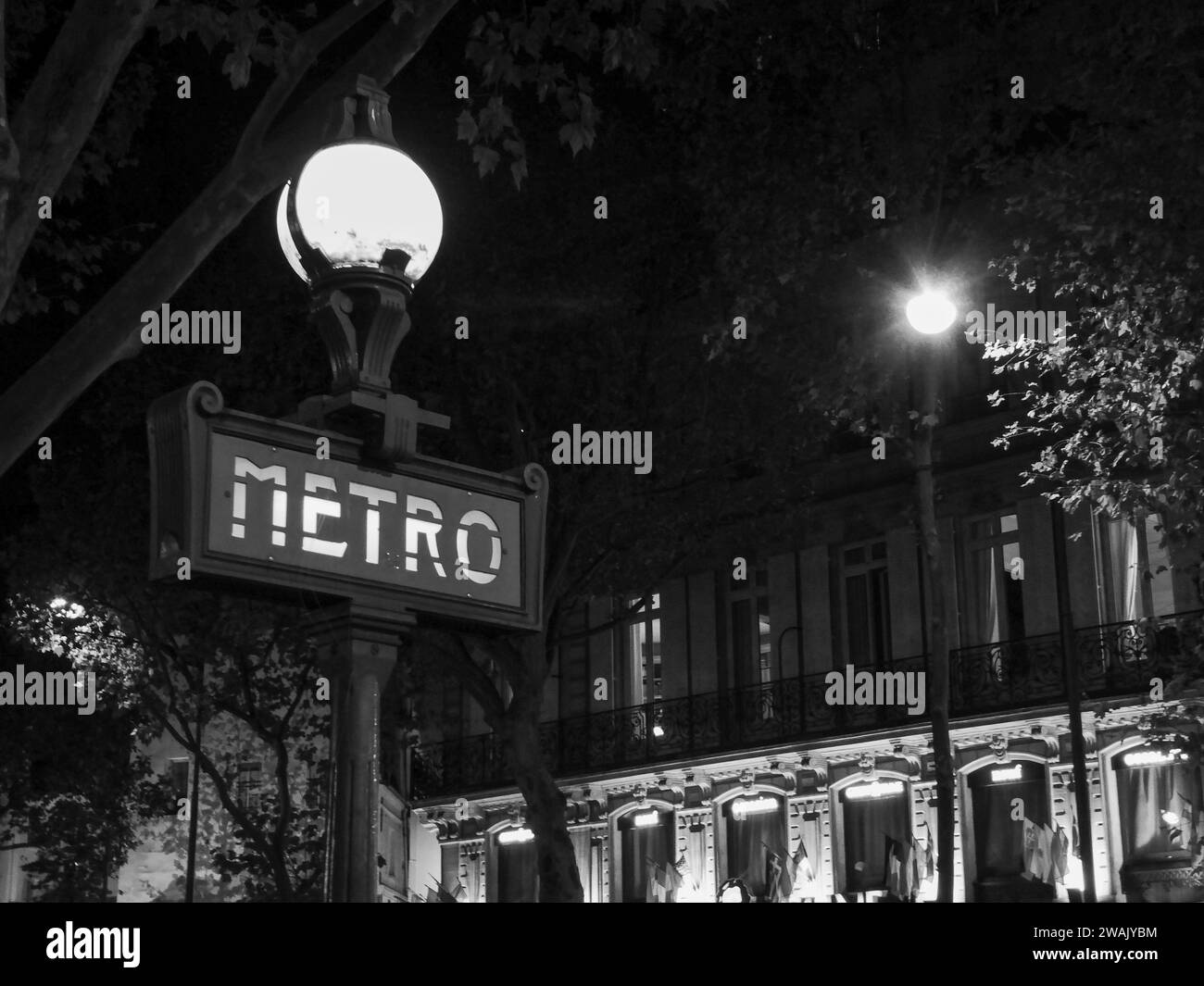 A street sign illuminated by surrounding street lights at night Stock ...