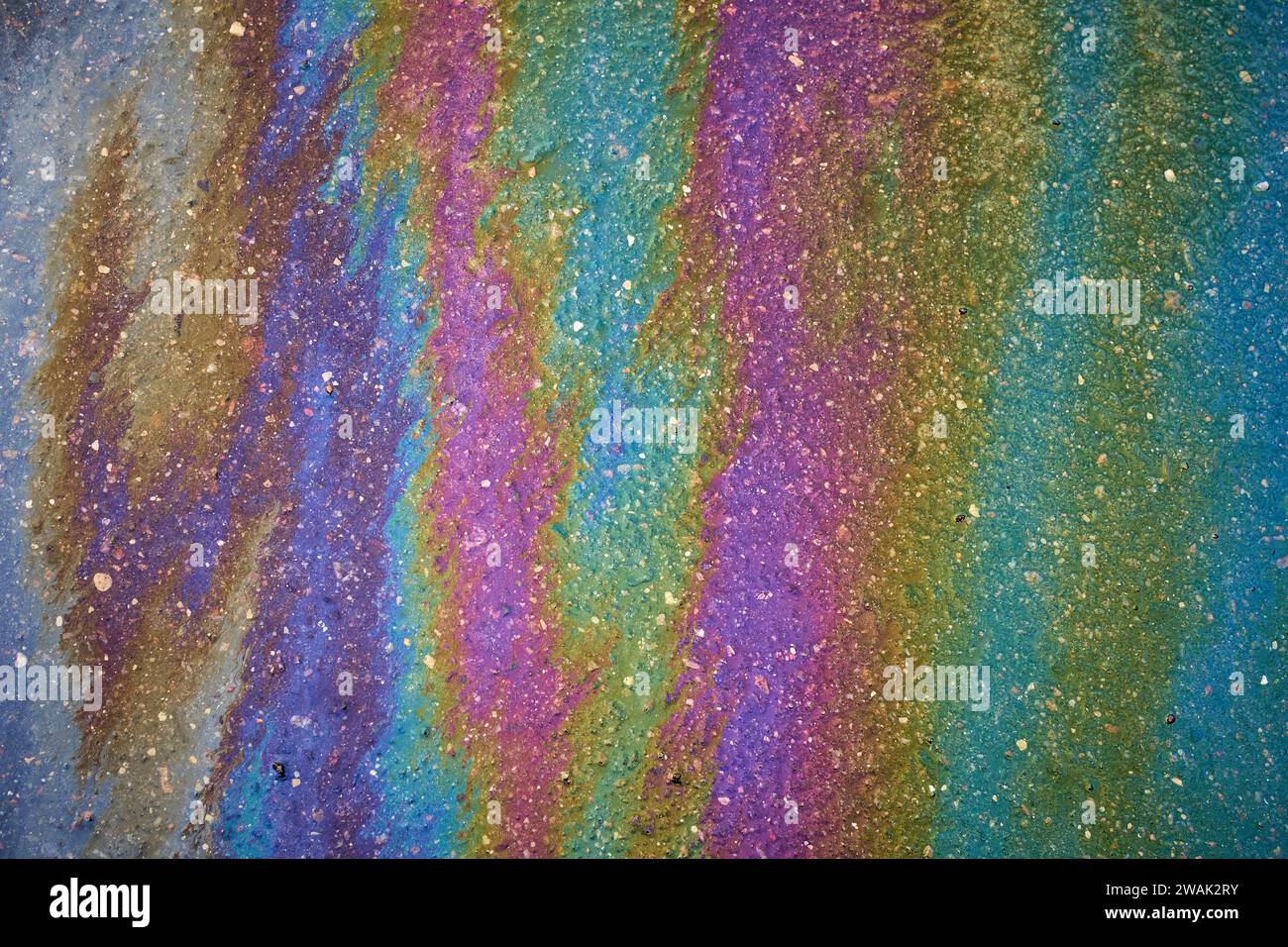 Petrol on the asphalt a big polluted puddle water. A rainbow slick of ...