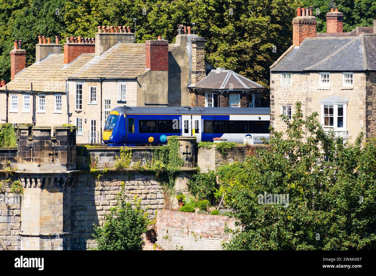A train enters the Pateley Bridge railway viaduct emerging from between ...