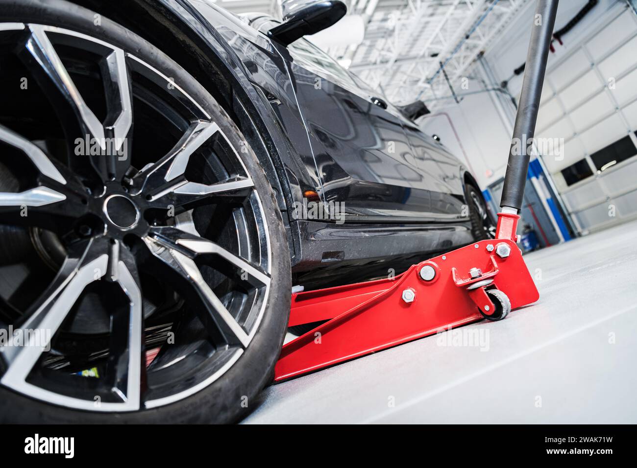 Modern Vehicle Lifted on a Red Hydraulic Car Jack Inside Dealership ...