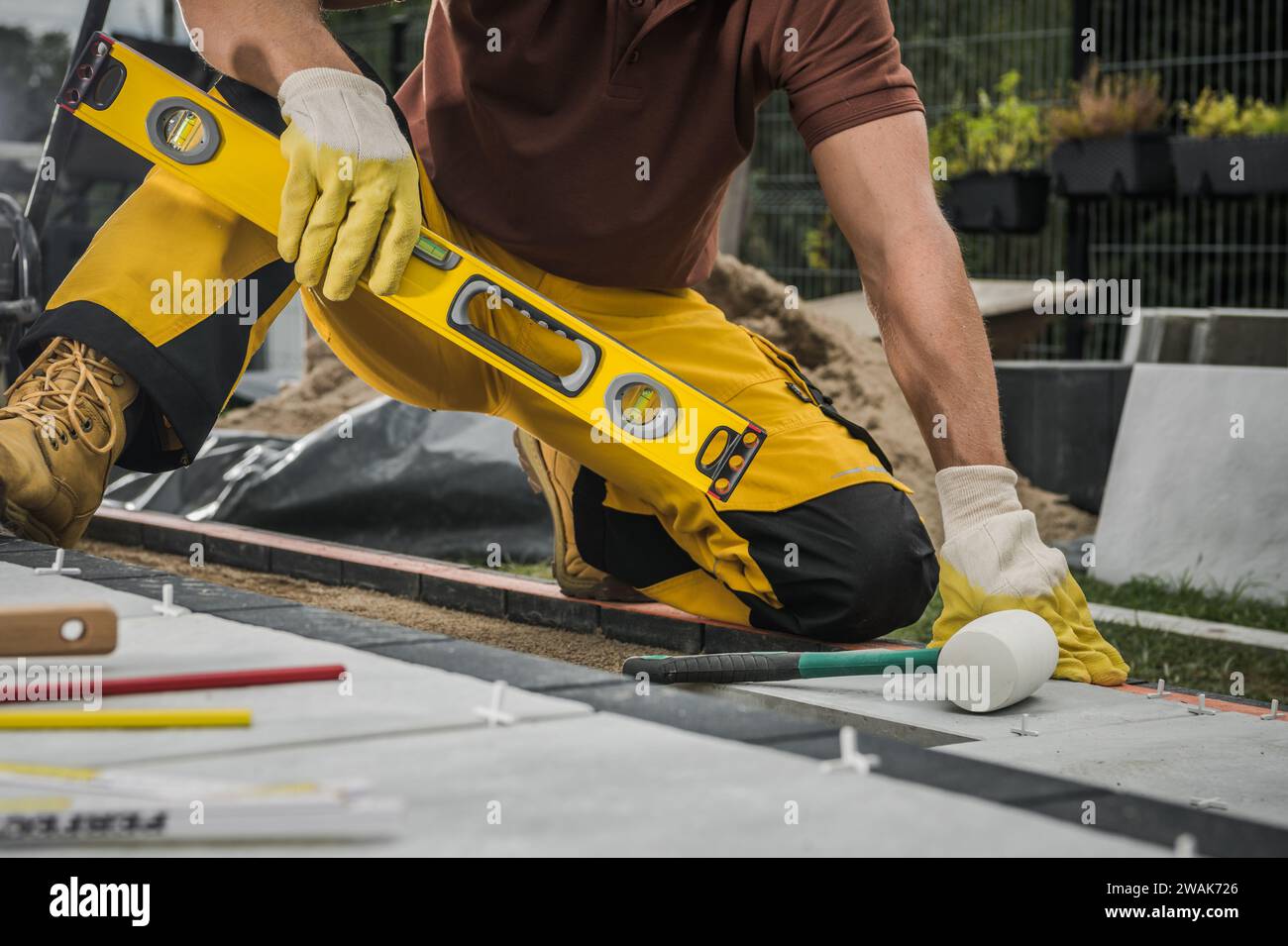Construction Worker with a Spirit Level Checking on a Patio Floor ...