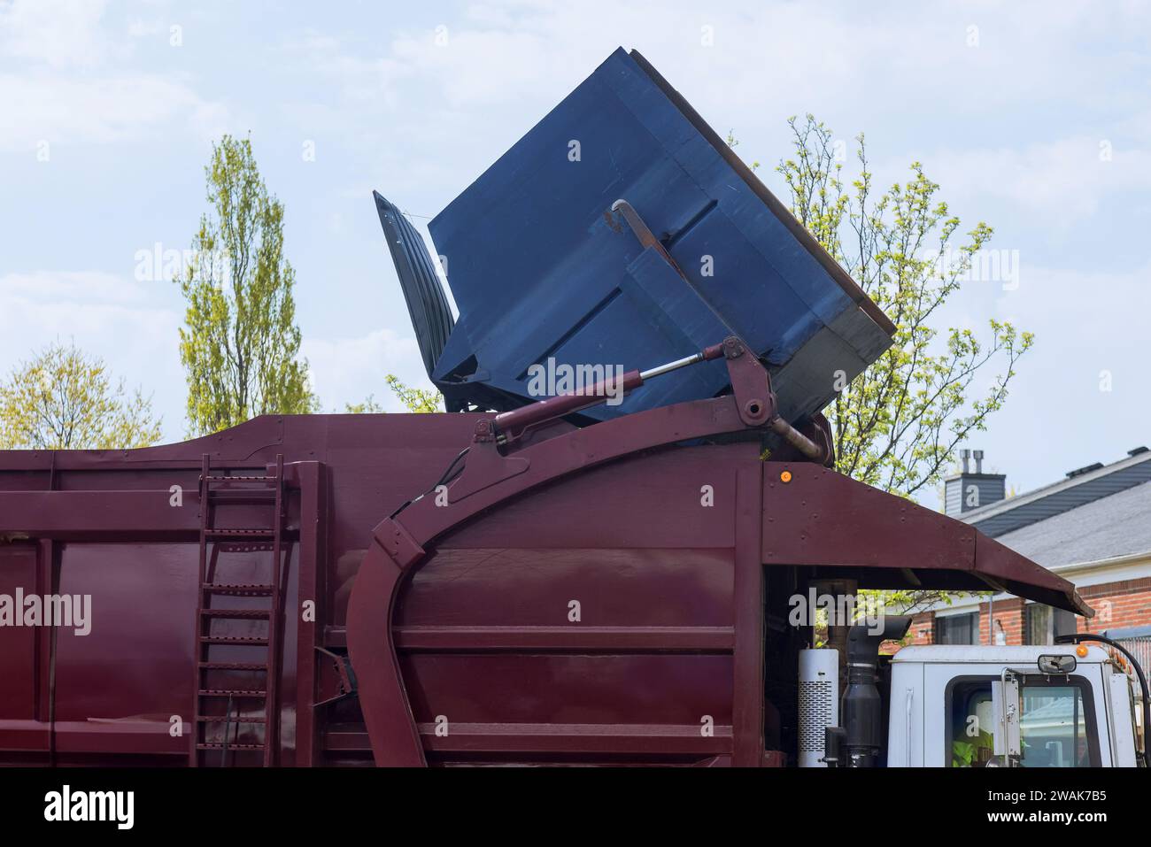 Waste is loaded into trash bin by municipal sanitation disposal service ...
