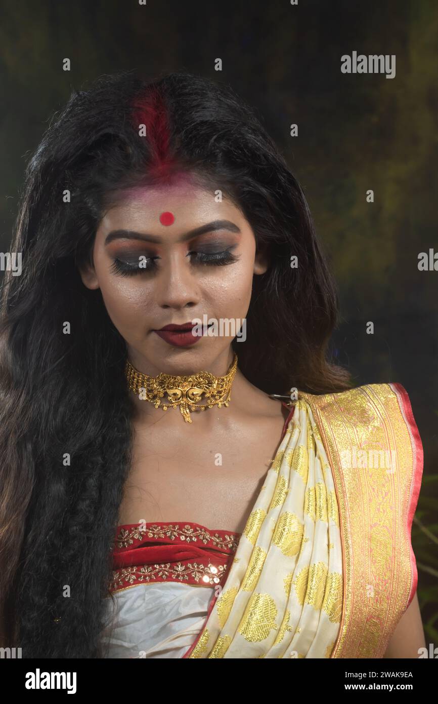 Portrait of a young beautiful woman with posing in front of a printed ...