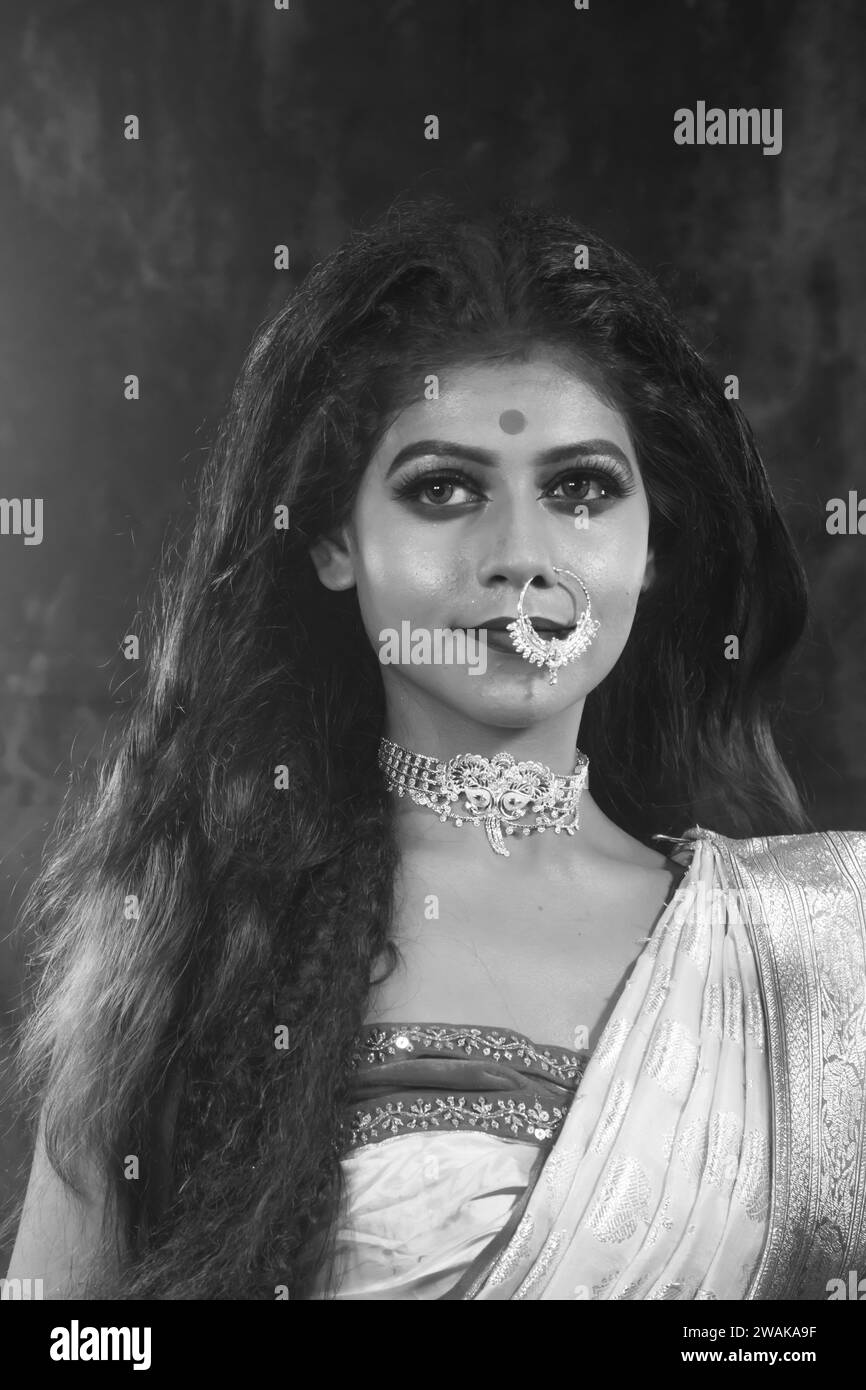 Portrait of a young beautiful woman with posing in front of a printed ...