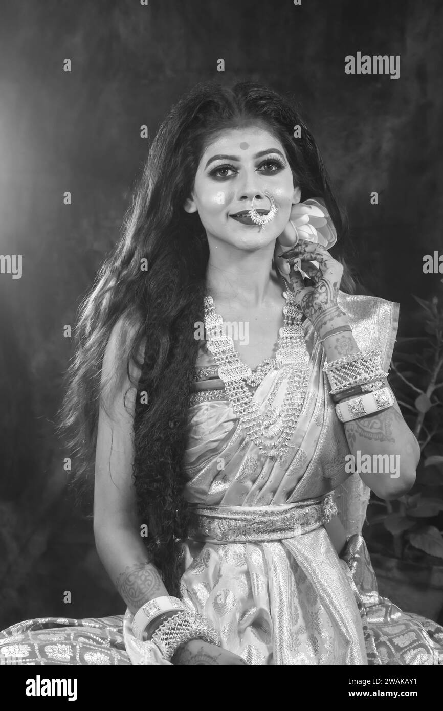 Portrait of a young beautiful woman with posing in front of a printed ...