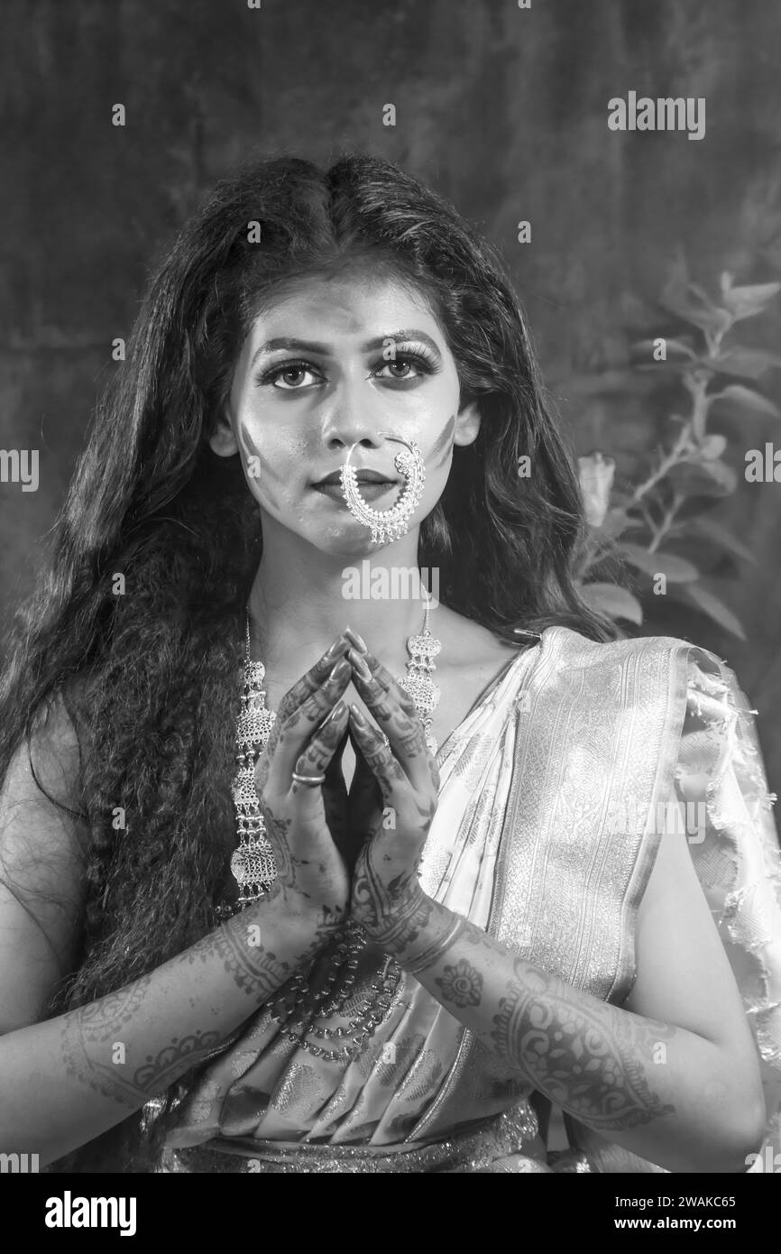 Portrait of a young beautiful woman with posing in front of a printed ...