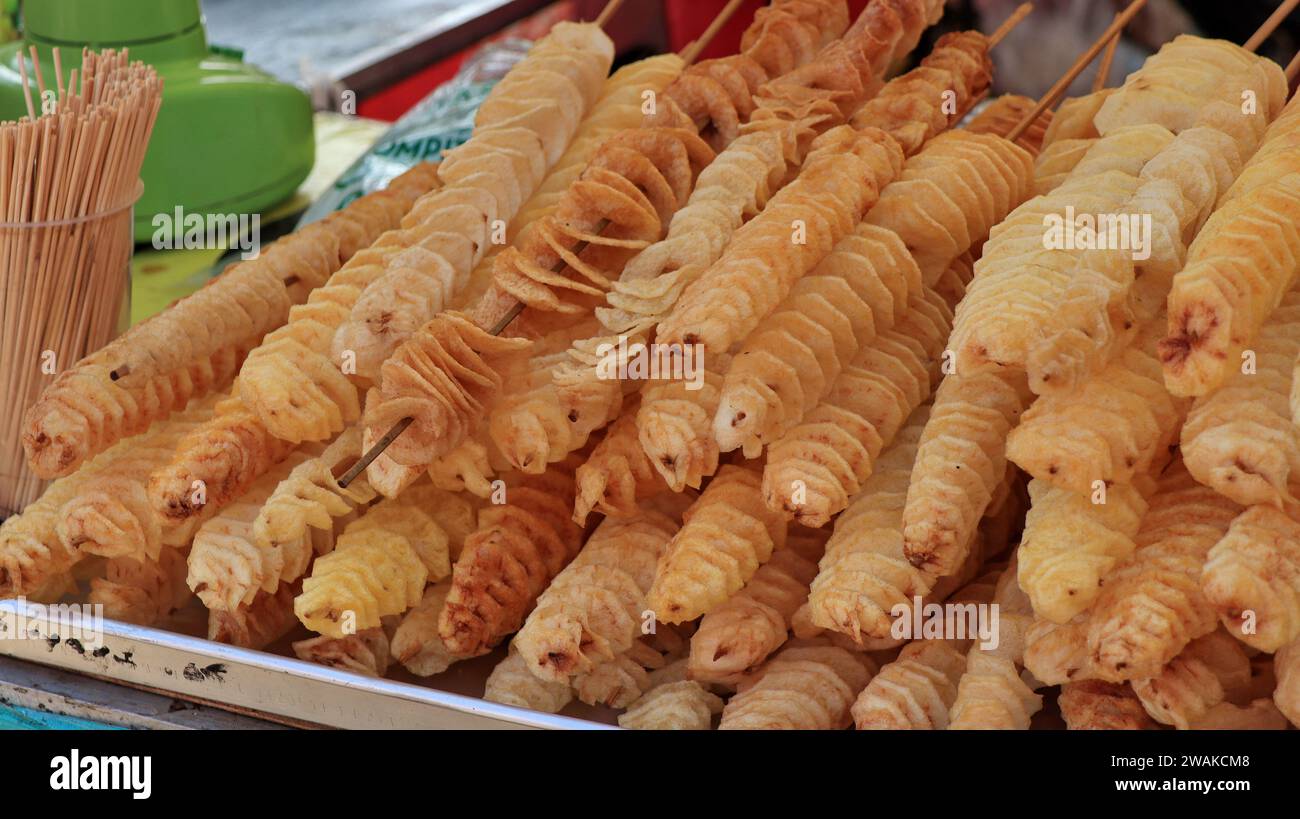 Potato chips on a stick. Natural chips are fried and sold at the fair ...